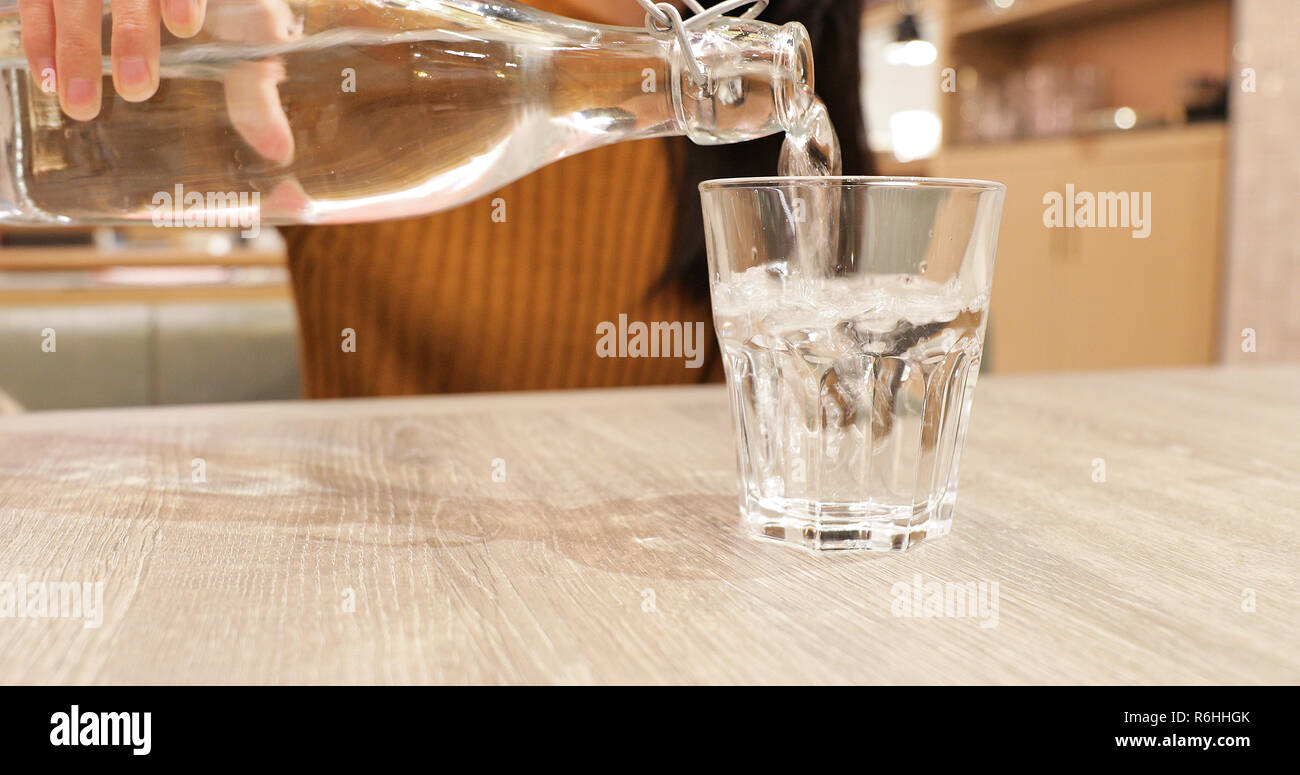 Woman pouring water into glass Stock Photo - Alamy