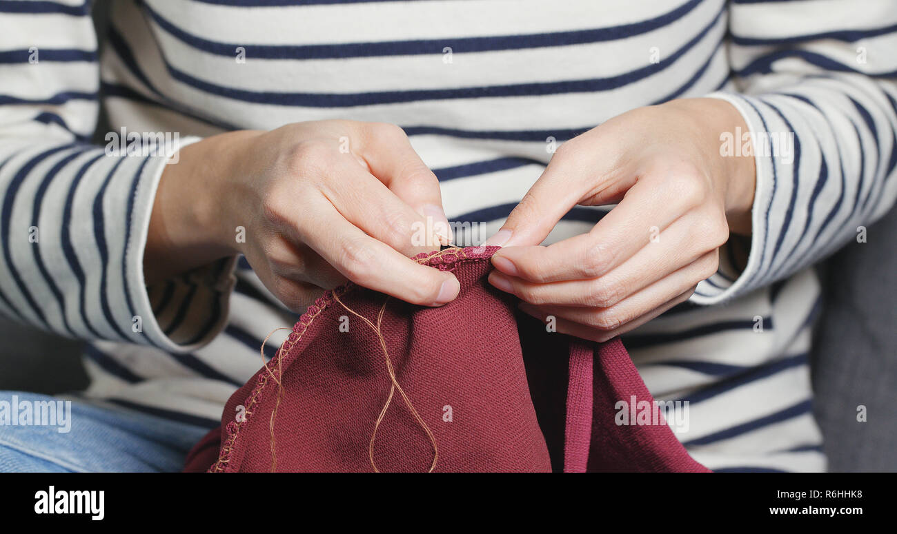 Woman Sews with a needle and thread Stock Photo - Alamy