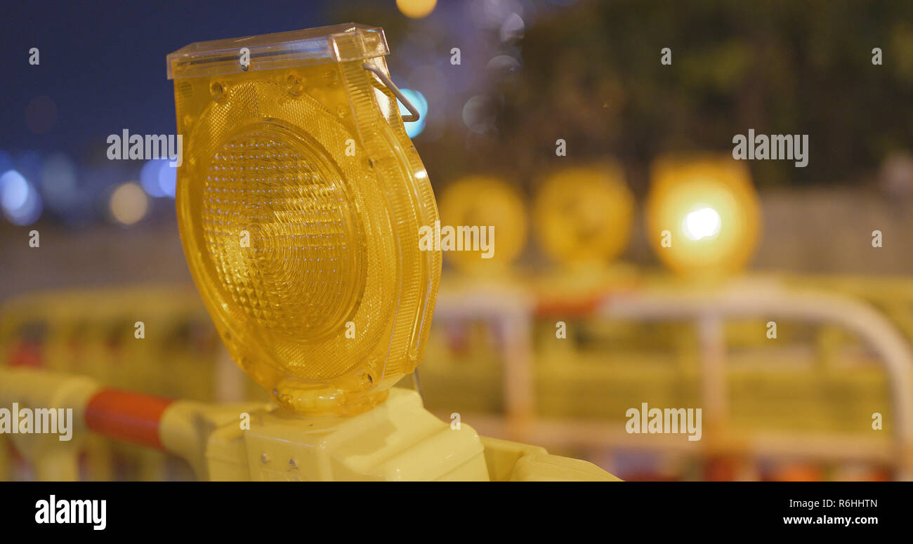 Caution sign is lit up in the city at night Stock Photo - Alamy