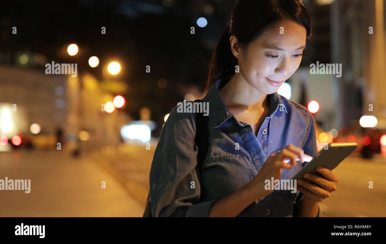 Woman use of mobile phone in the city at night Stock Photo - Alamy
