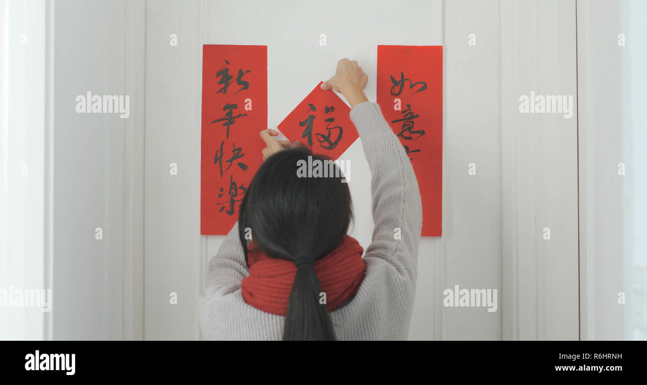 Woman sticking chinese calligraphy on the door for lunar new year Stock ...