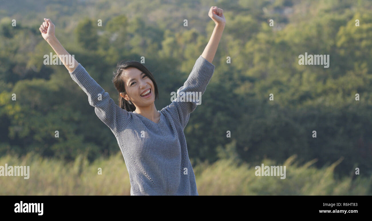Excited woman raising hand up Stock Photo - Alamy