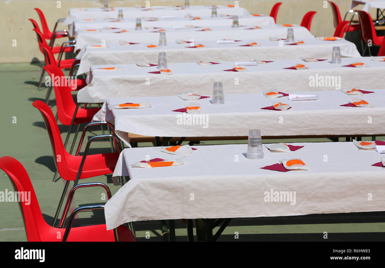 many tables set outdoors with benches for a community lunch Stock Photo ...