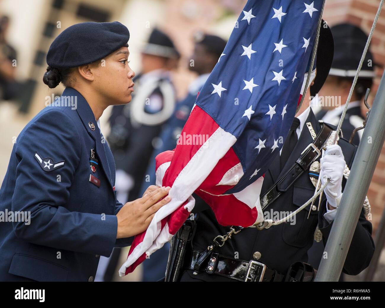 A Security Forces Airman unfurls the American Flag to be raised up at ...
