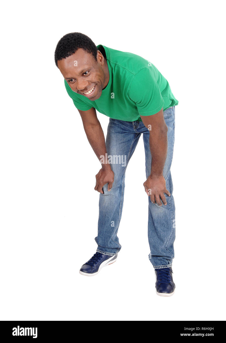Happy African man in jeans bending down Stock Photo - Alamy