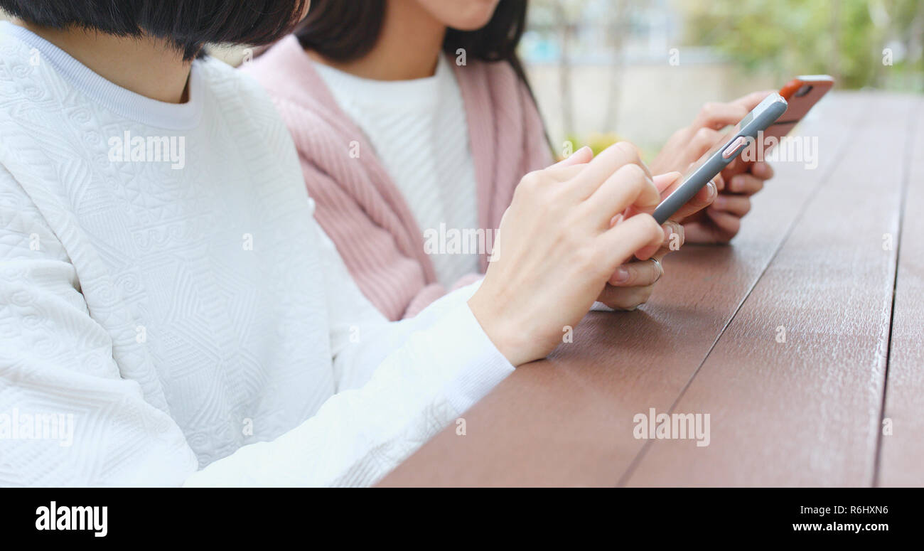 Friends using cellphone together Stock Photo - Alamy
