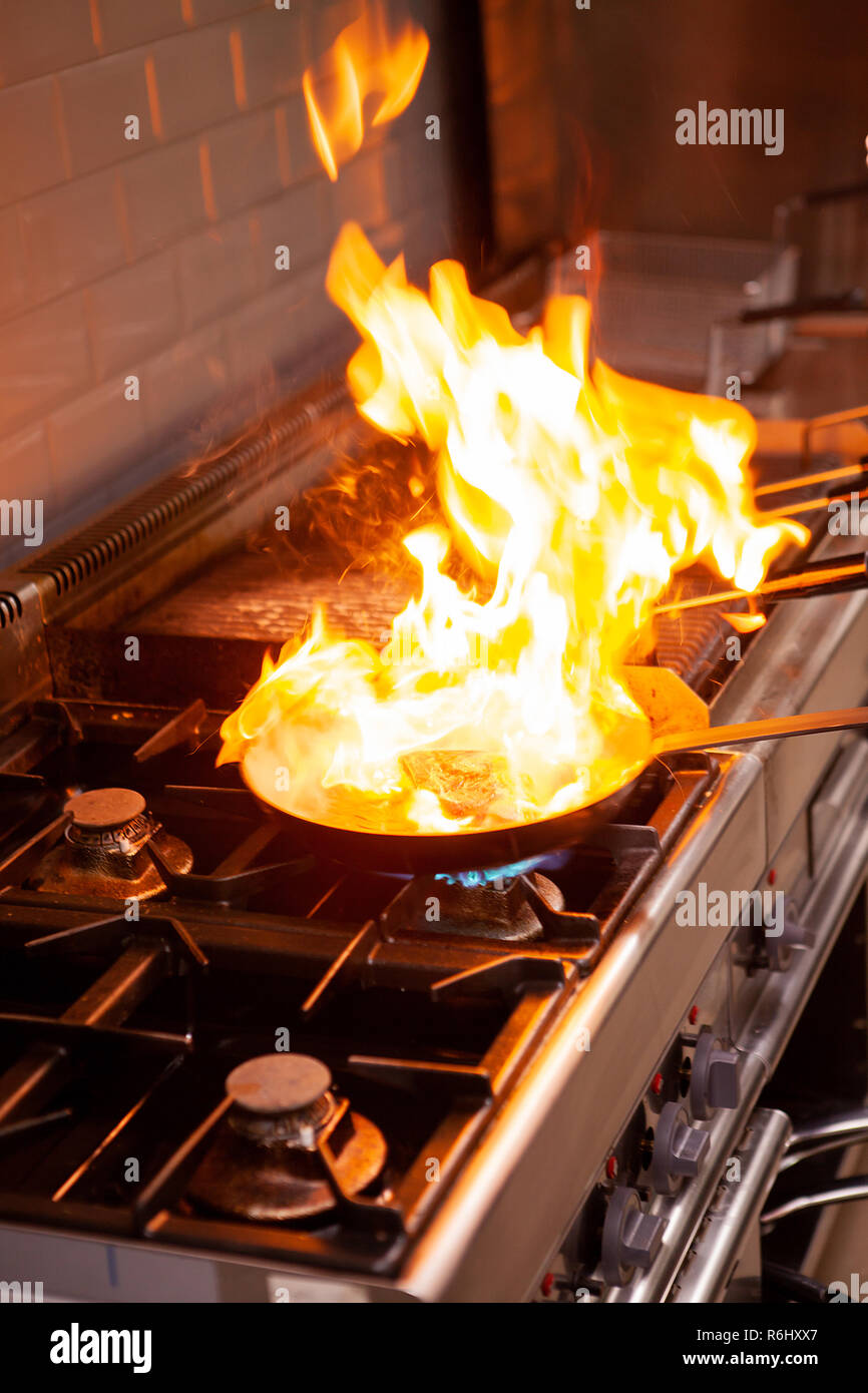 Chef cooking with high fire in kitchen restaurant Stock Photo - Alamy