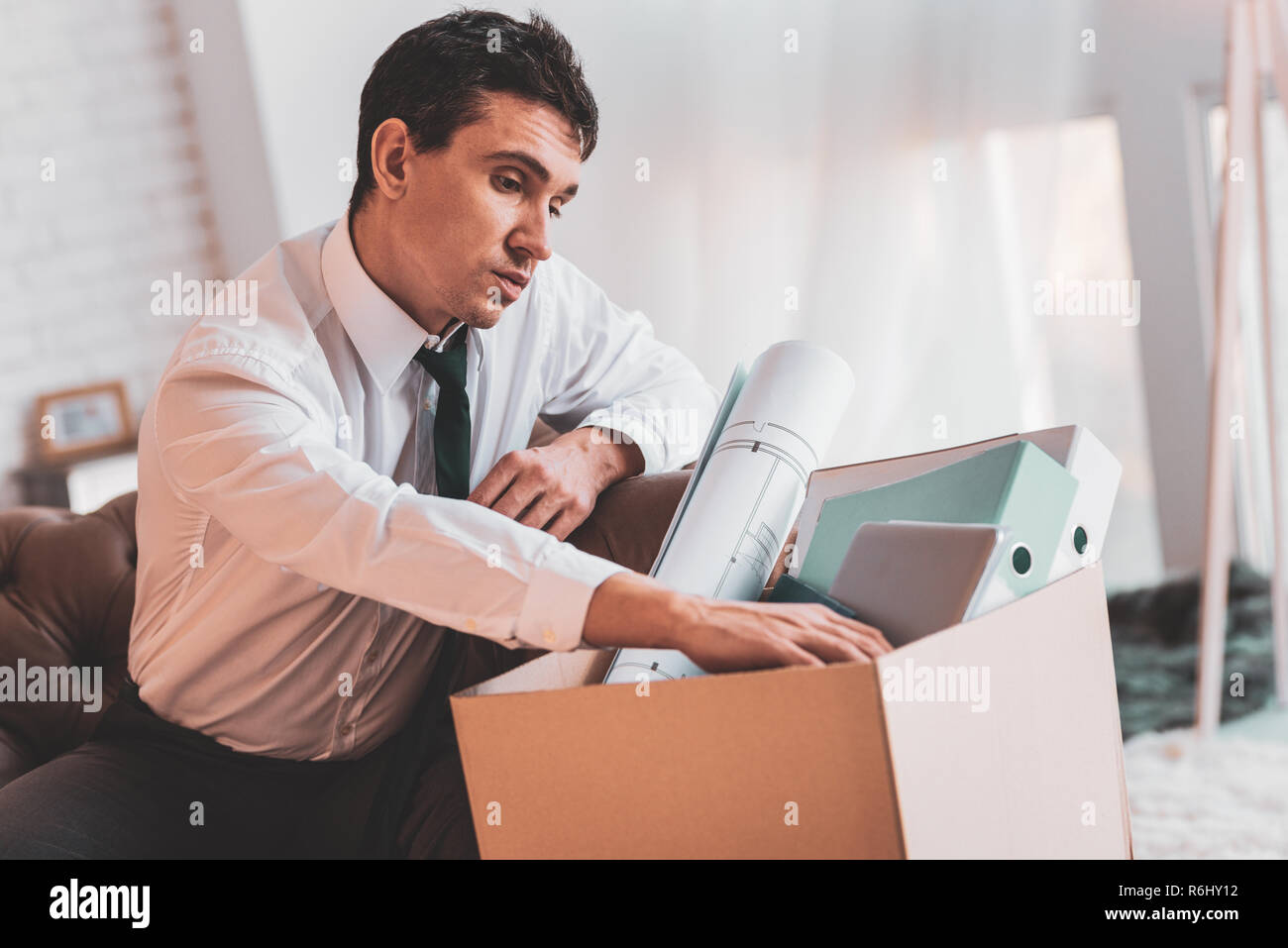 Calm engineer taking things from the box after losing his job Stock ...
