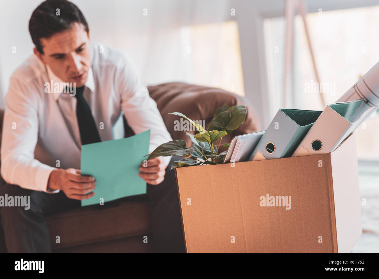 Serious man reading a letter after losing his job Stock Photo - Alamy