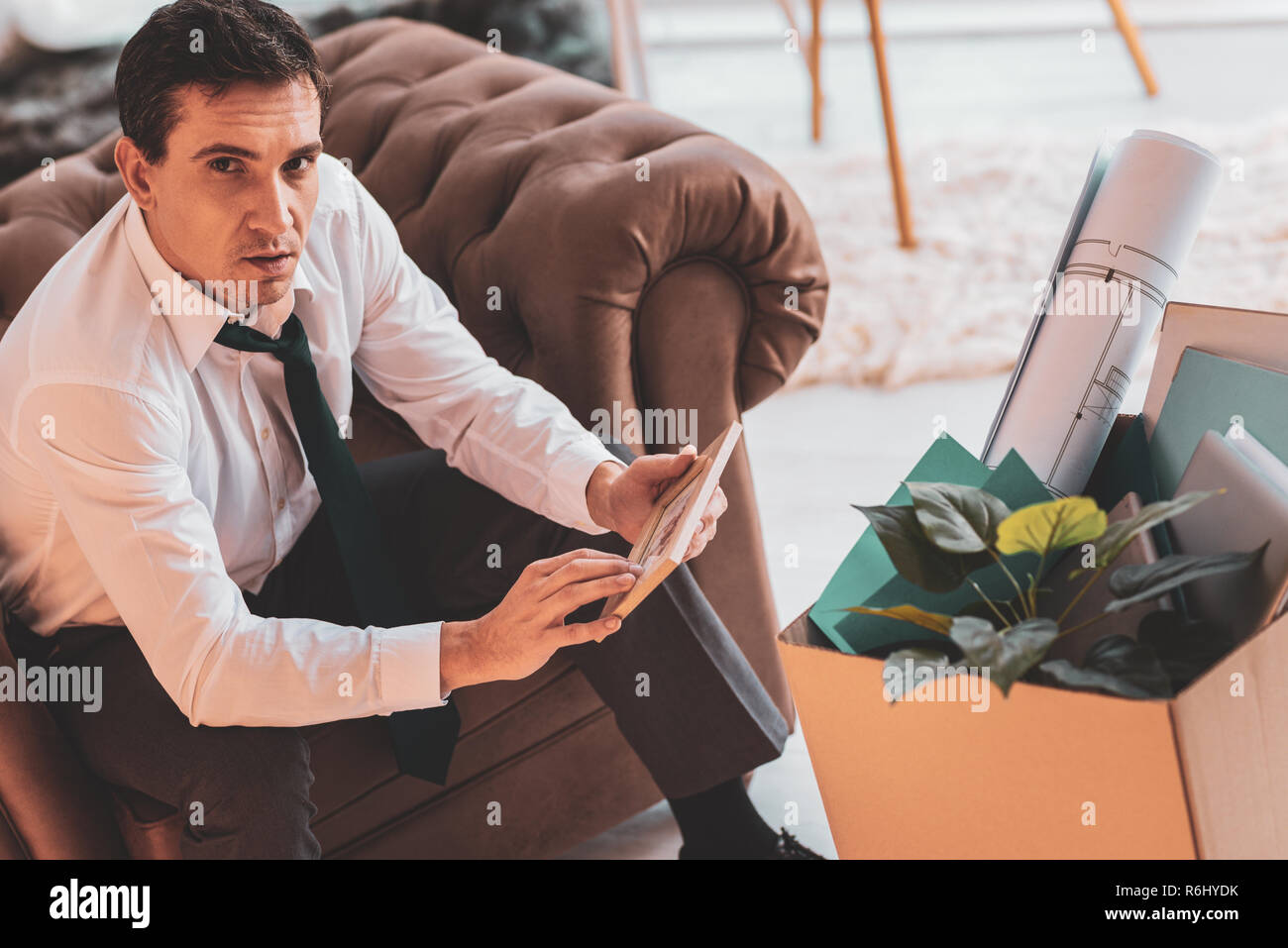 Serious person looking at the photo and feeling worried Stock Photo - Alamy