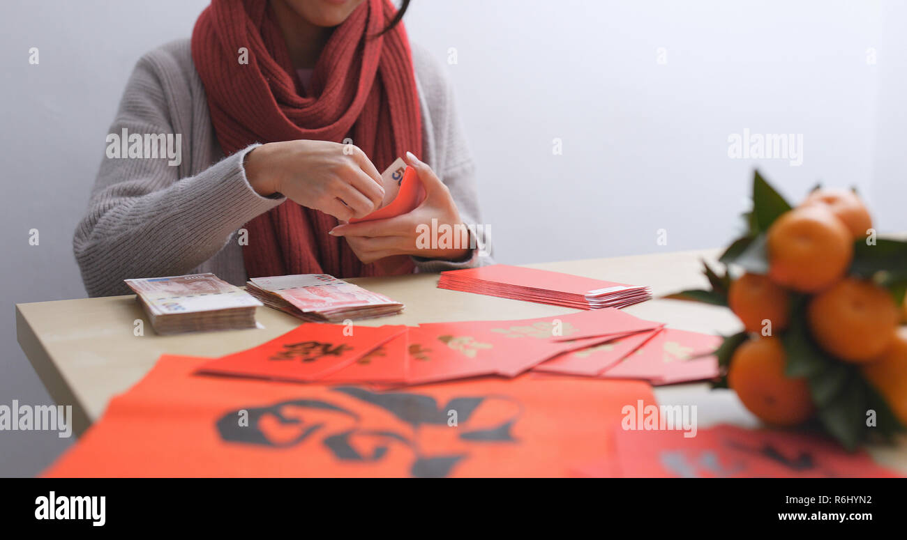 Woman putting money into red packet for lunar new year Stock Photo - Alamy