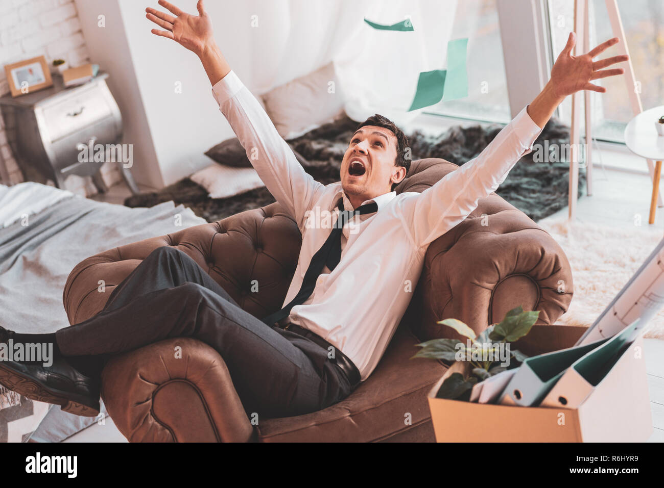 Emotional man throwing documents after losing his job Stock Photo - Alamy