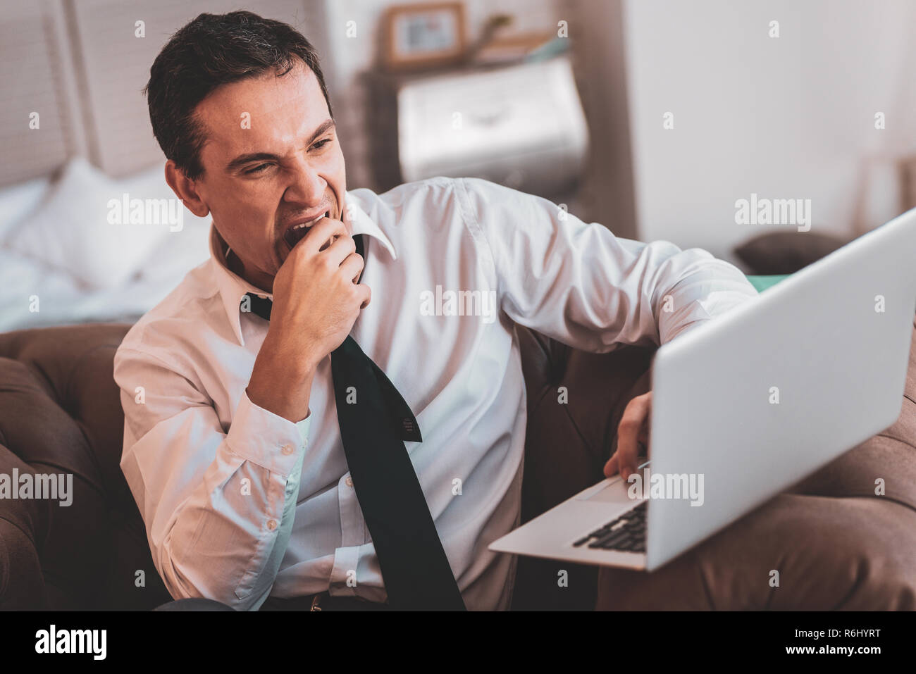 Sleepy man feeling tired and looking at the screen Stock Photo - Alamy