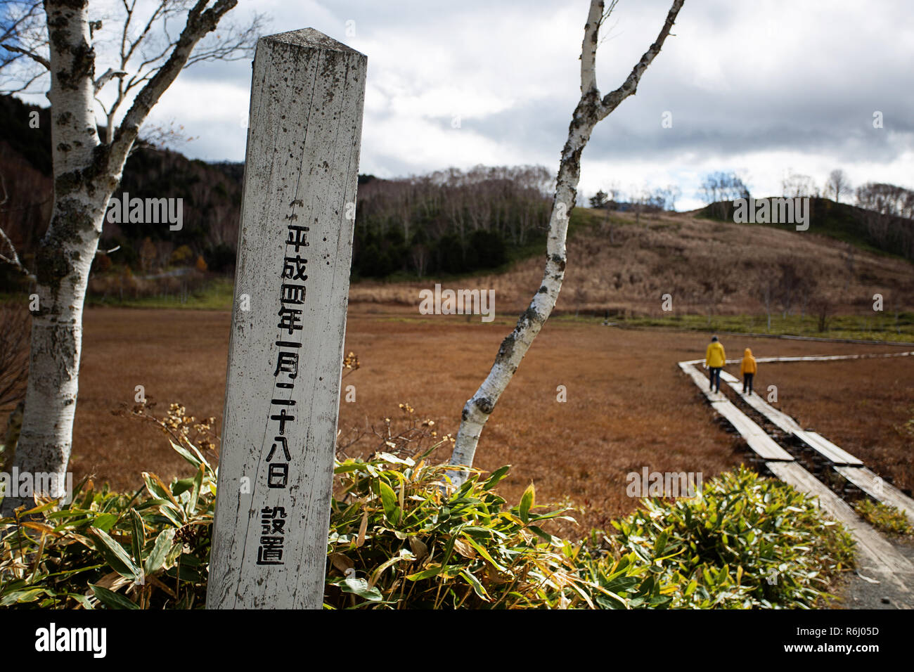 JApanese wooden sign in front of swamp, mother and son walking on ...