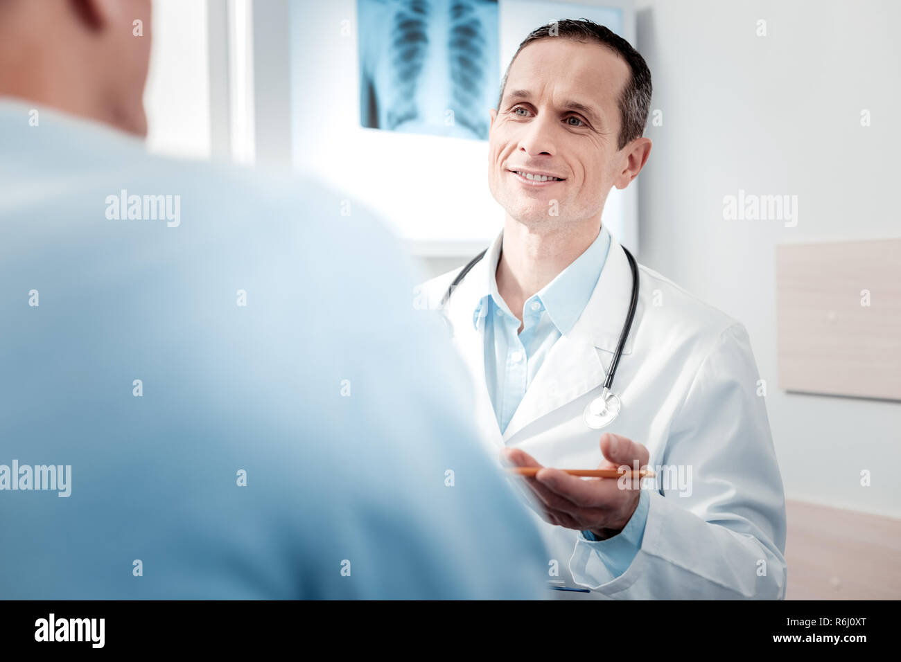 Positive delighted doctor asking questions Stock Photo - Alamy