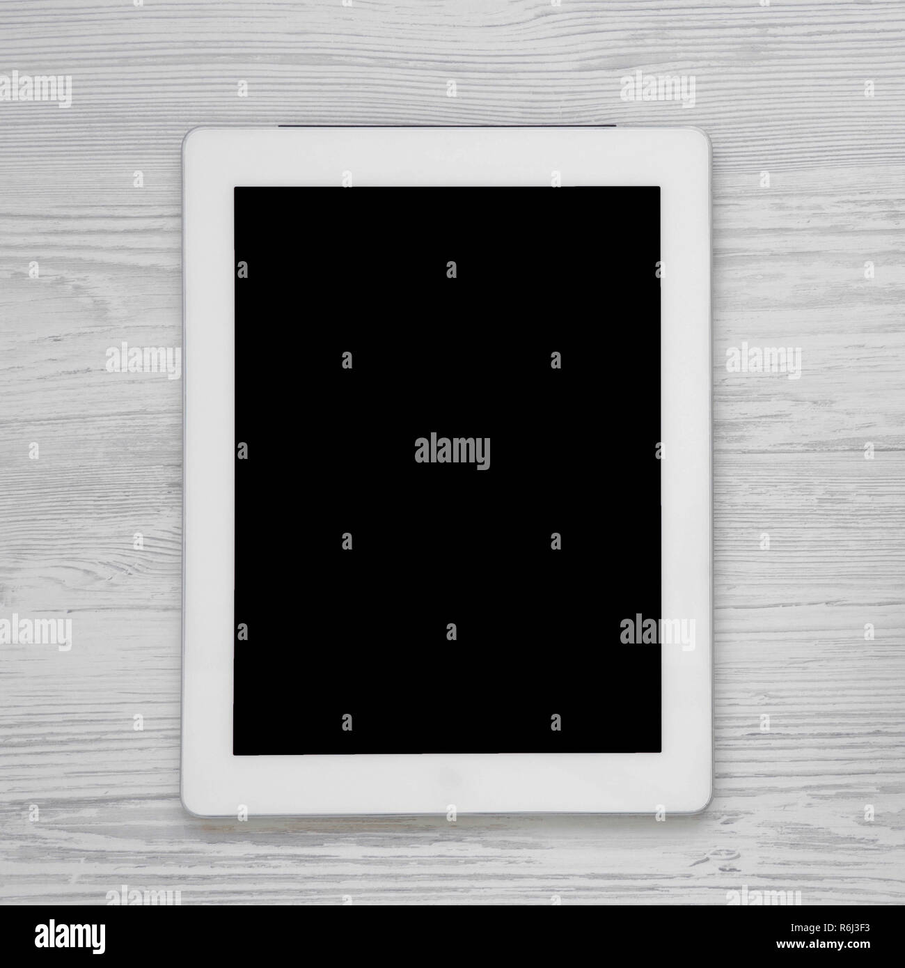 Minimal work space with tablet on white wooden surface, overhead view ...