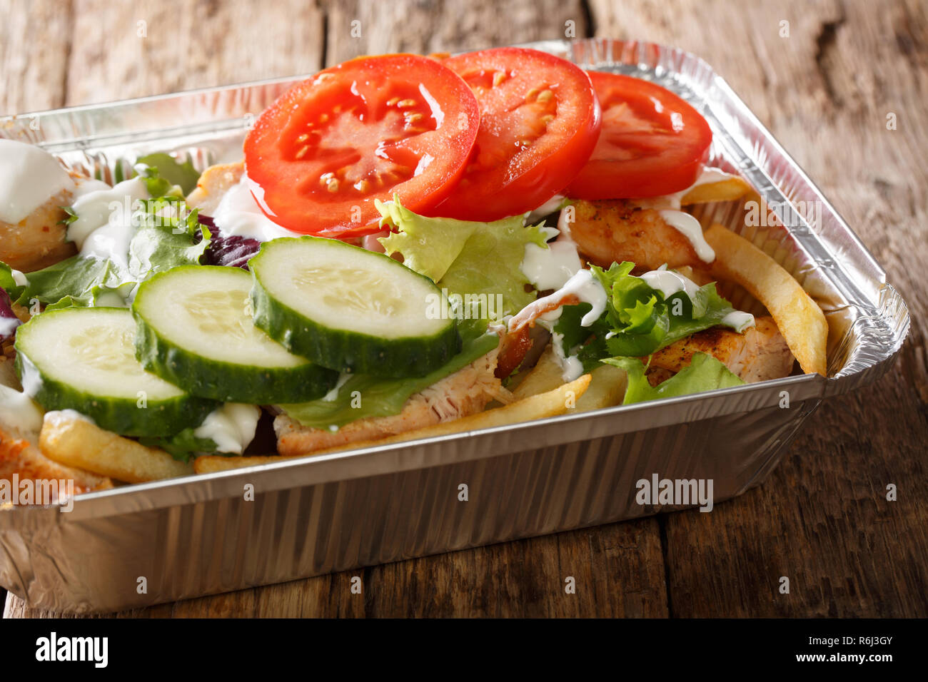 Delicious dinner Dutch kapsalon of french fries, chicken, fresh salad ...