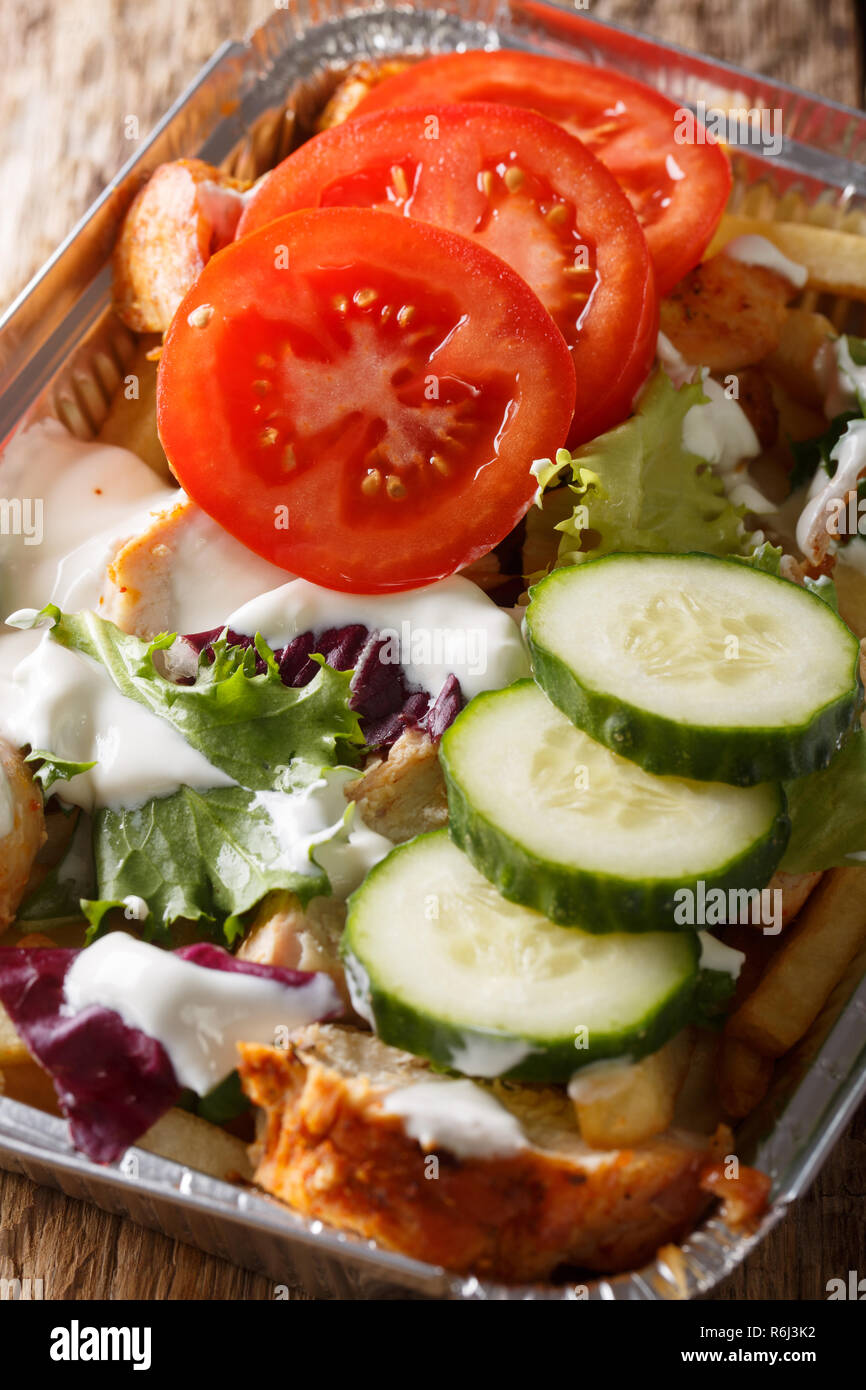 Dutch fast food kapsalon of french fries, chicken, fresh salad and ...