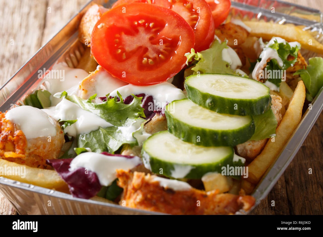 Traditional Dutch fast food kapsalon of french fries, chicken, fresh ...