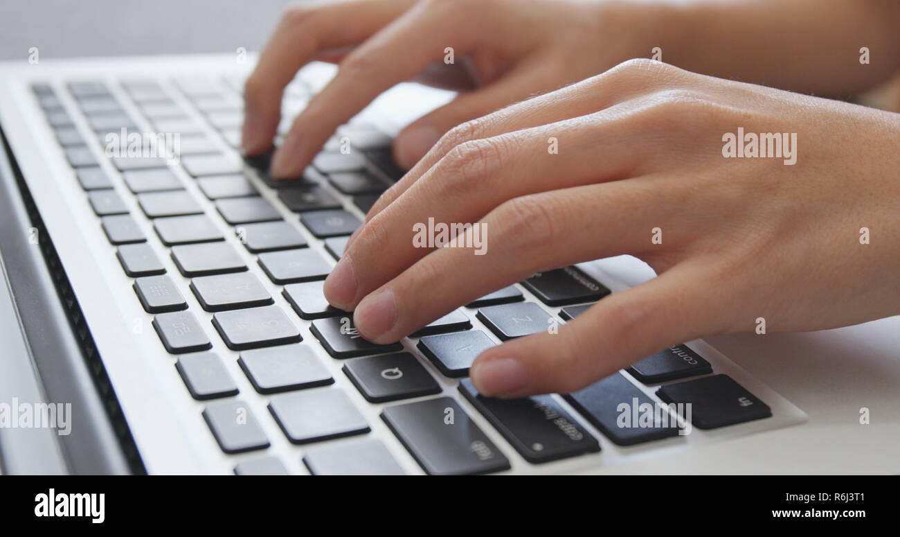 Typing on laptop computer keyboard Stock Photo - Alamy
