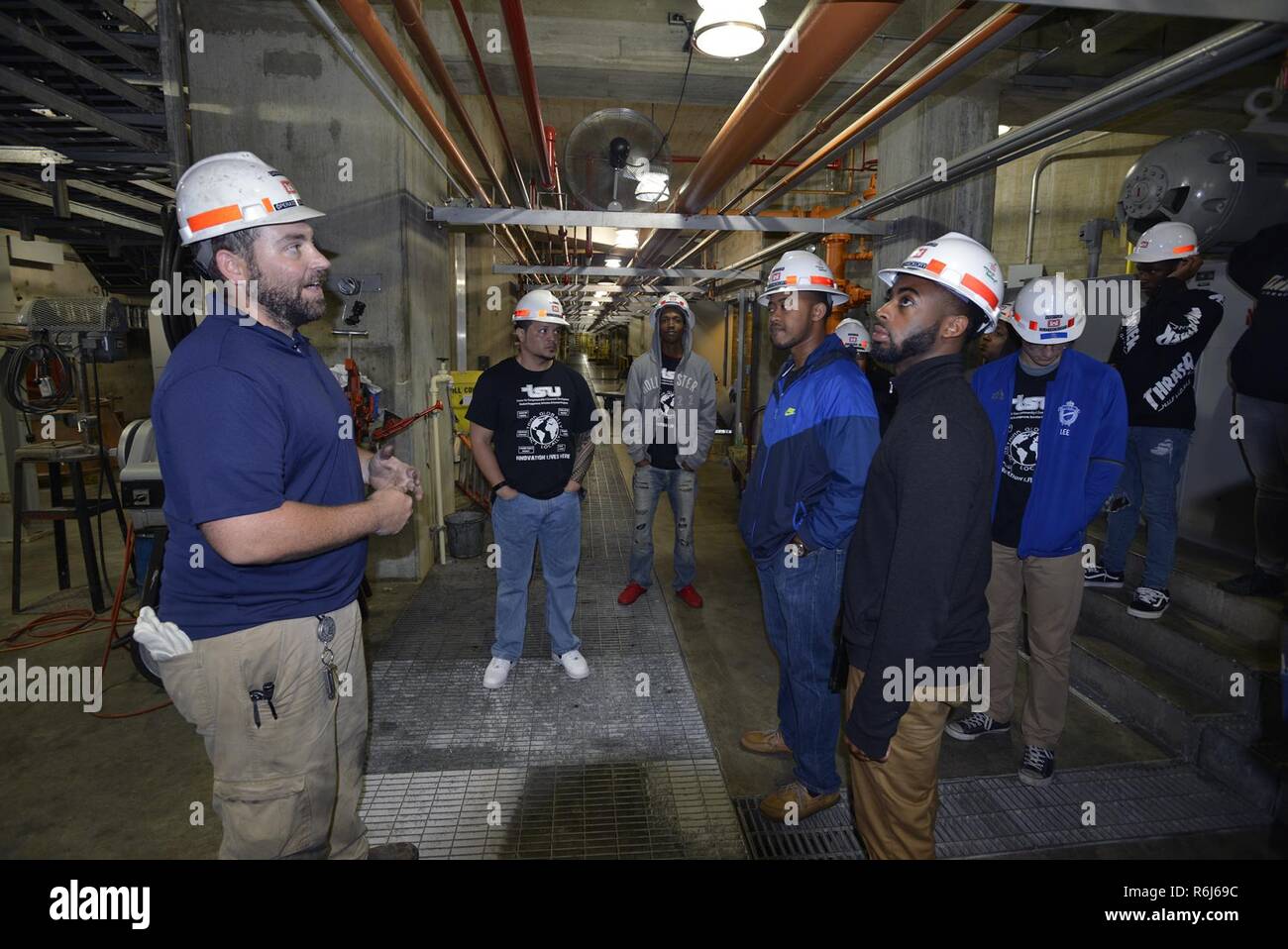 John Bell, hydropower operator trainee, explains to a group of high ...
