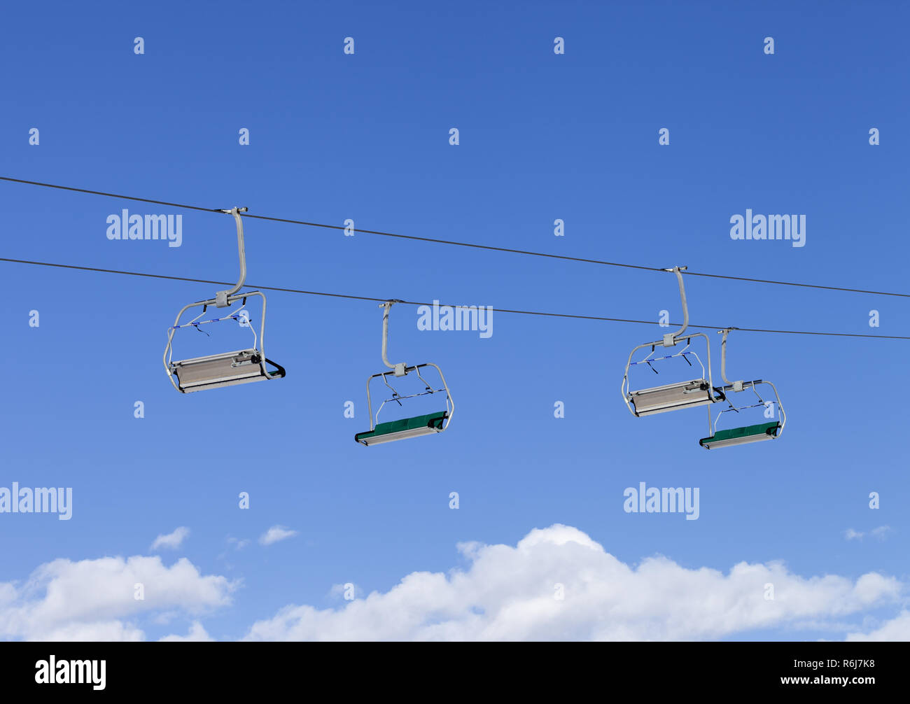 Sunlight ski-lift and blue sky with clouds at ski resort on sun winter ...
