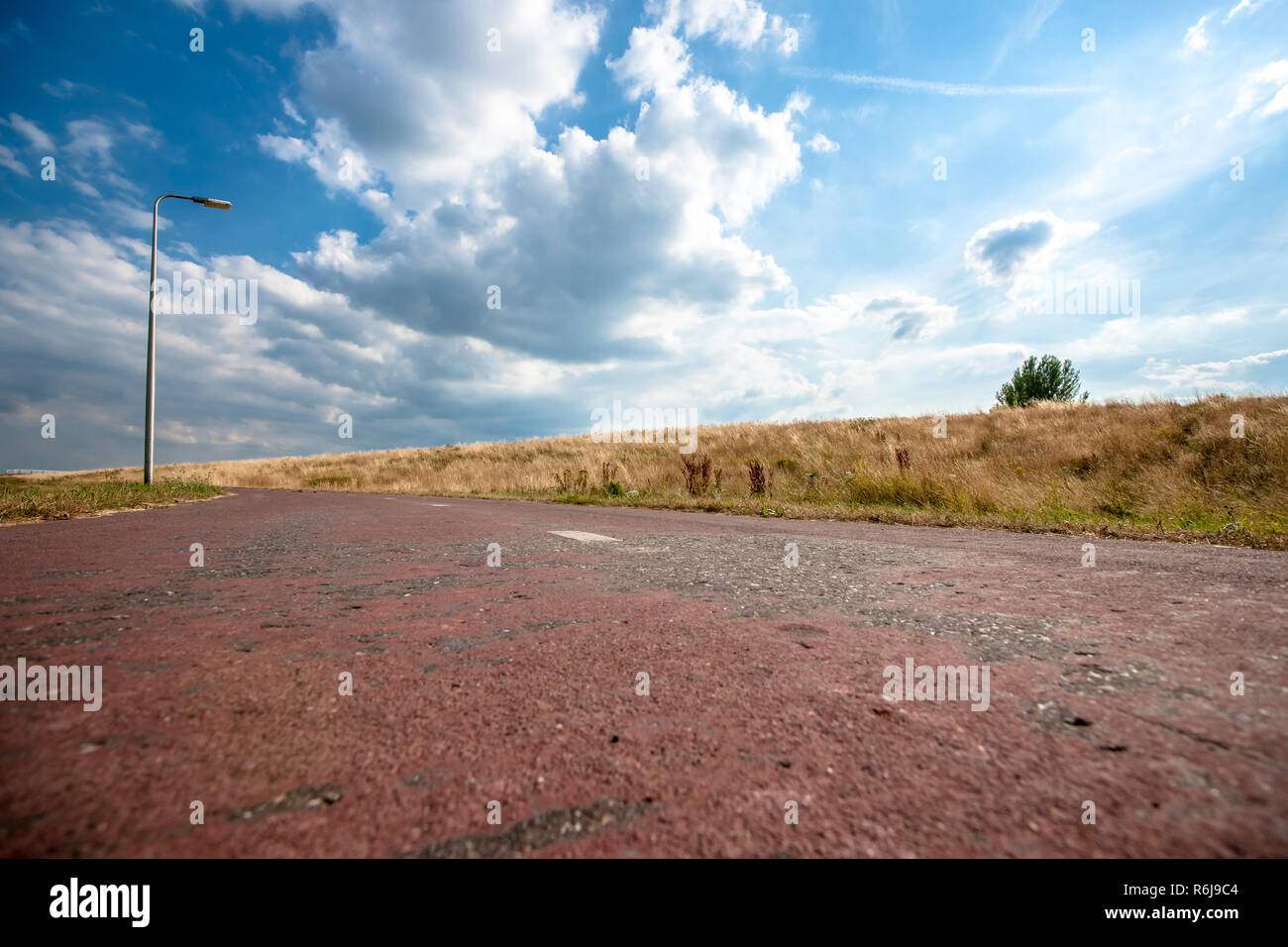 Paved hard stone road along dutch cultivated landscape. Blue skies ...