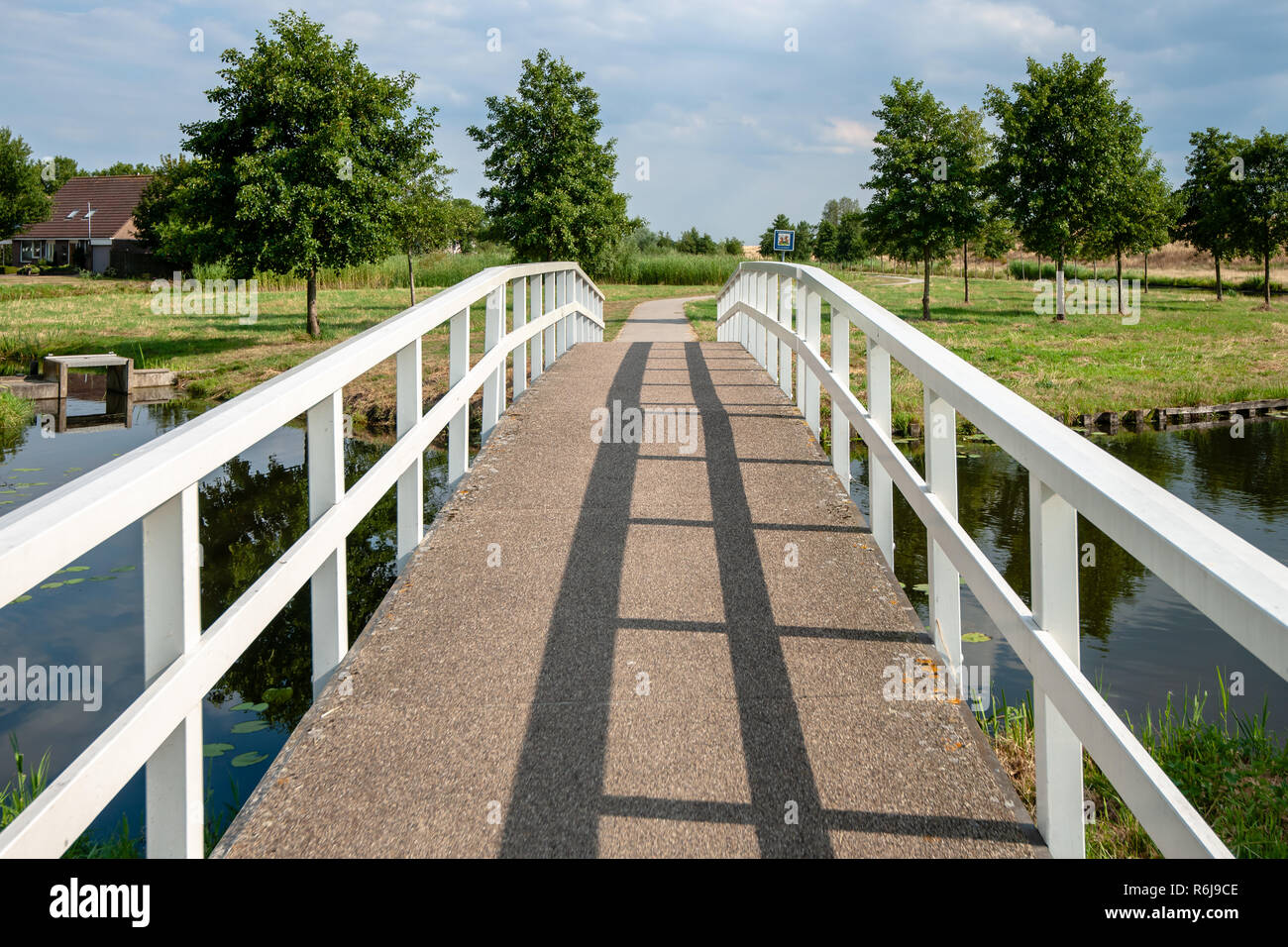 Traditional white wooden footbridge or cyclists bridge in a park or ...