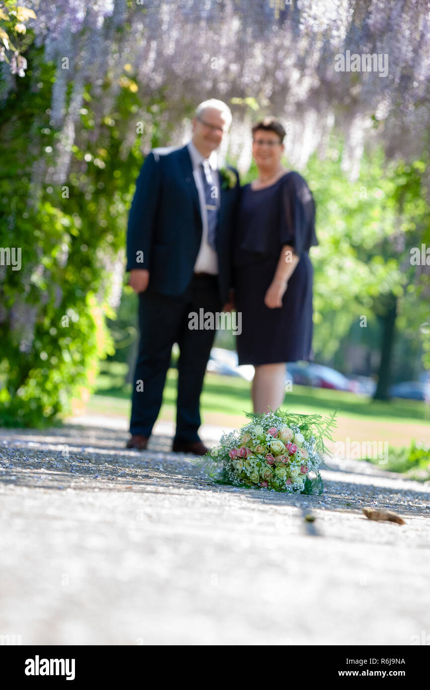 Nicely flowers bouquet on the ground with an enamored pair in the ...