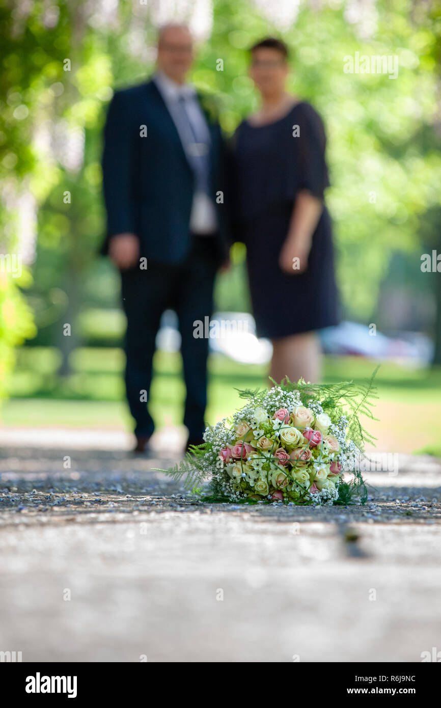 Nicely flowers bouquet on the ground with an enamored pair in the ...