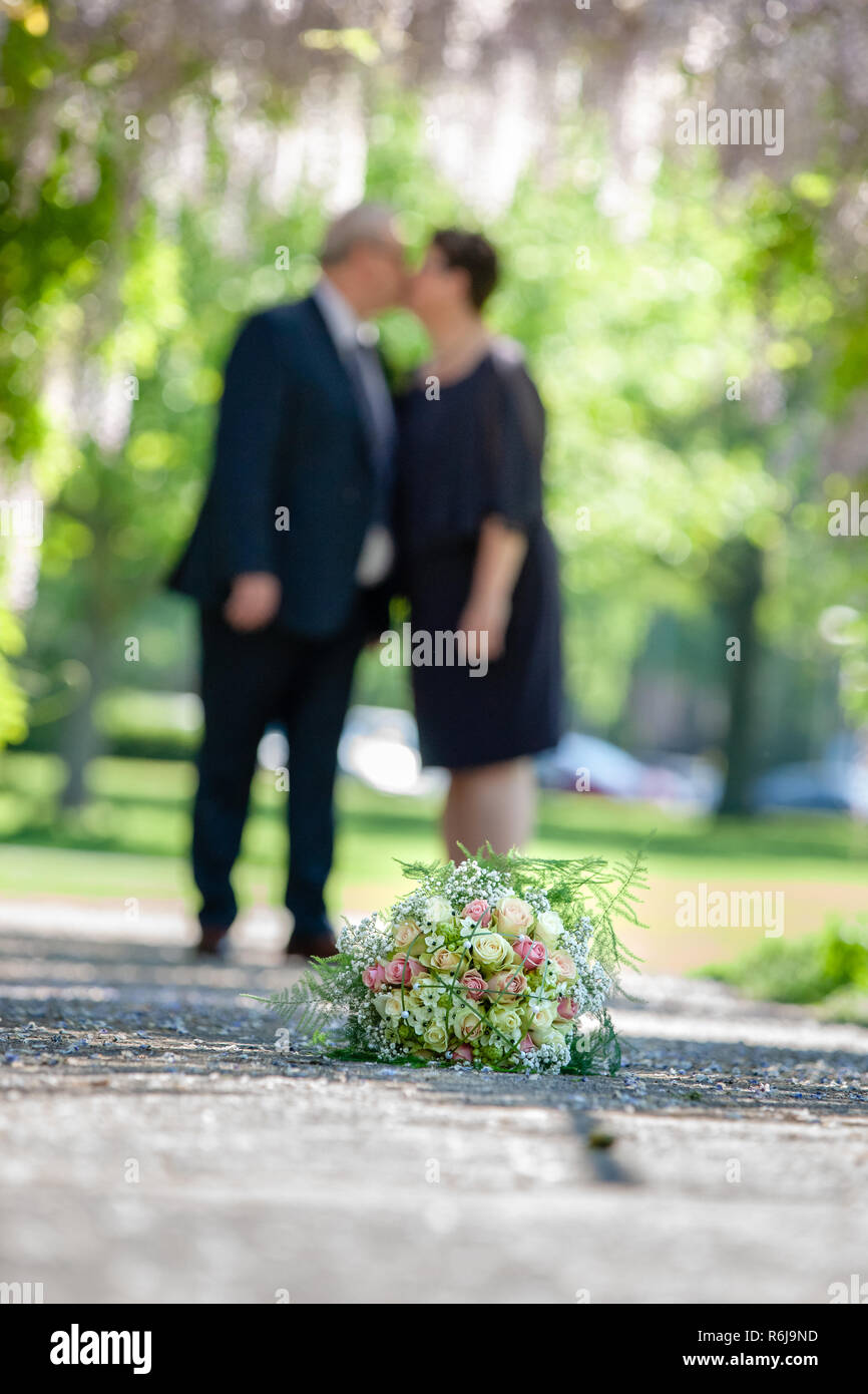 Nicely flowers bouquet on the ground with an enamored pair in the ...