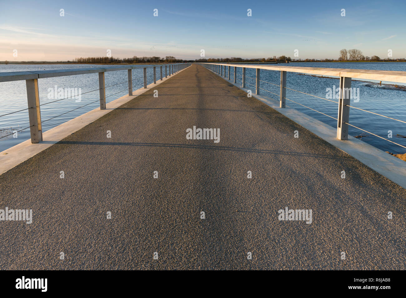Details of a concrete walkway along the waterfront against a river dike ...