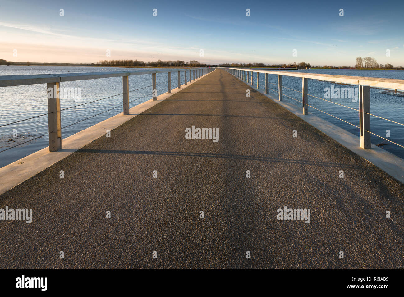 Details of a concrete walkway along the waterfront against a river dike ...