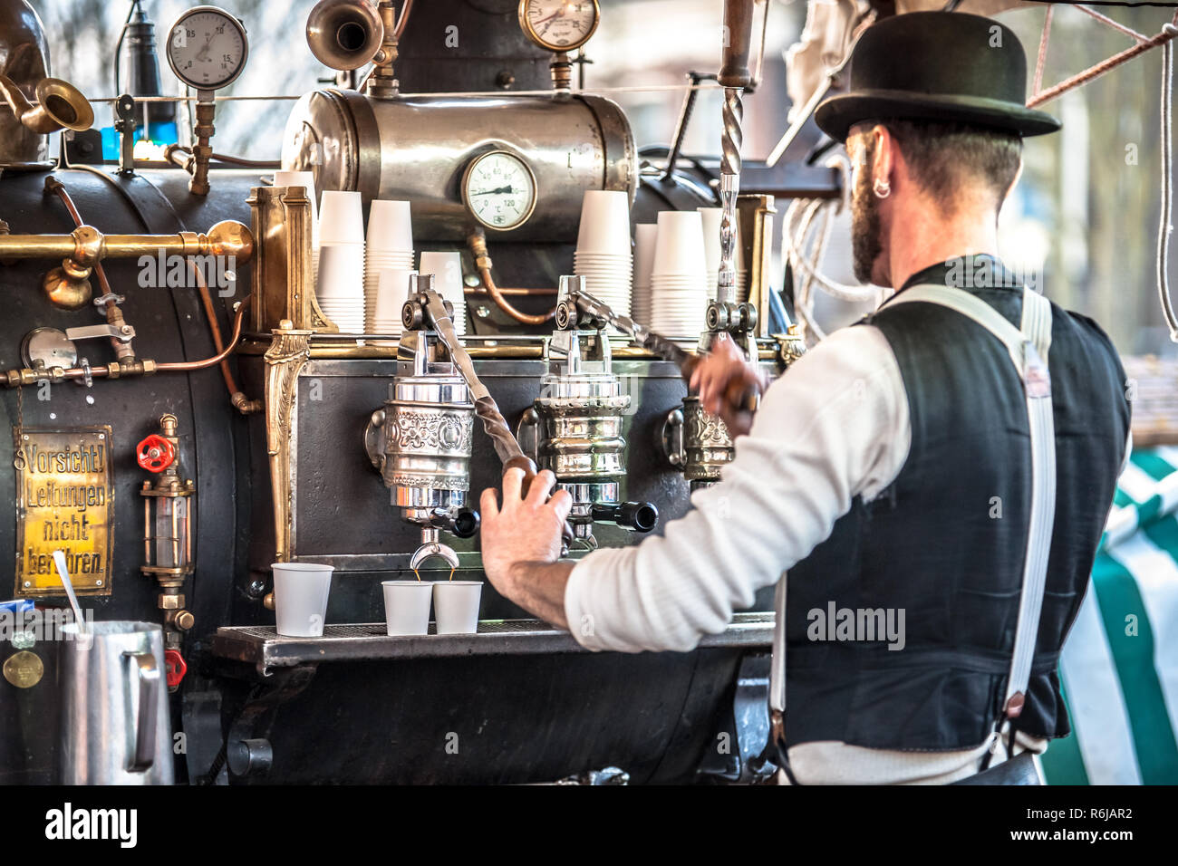 Vintage barista prepare coffee to customer in old style machine with ...