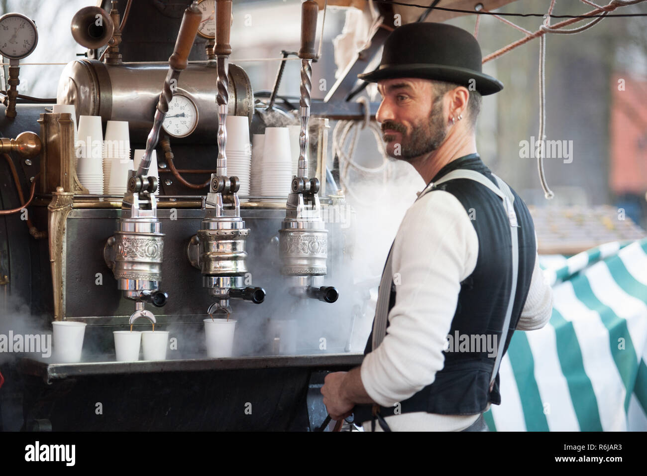 Vintage barista prepare coffee to customer in old style machine with ...