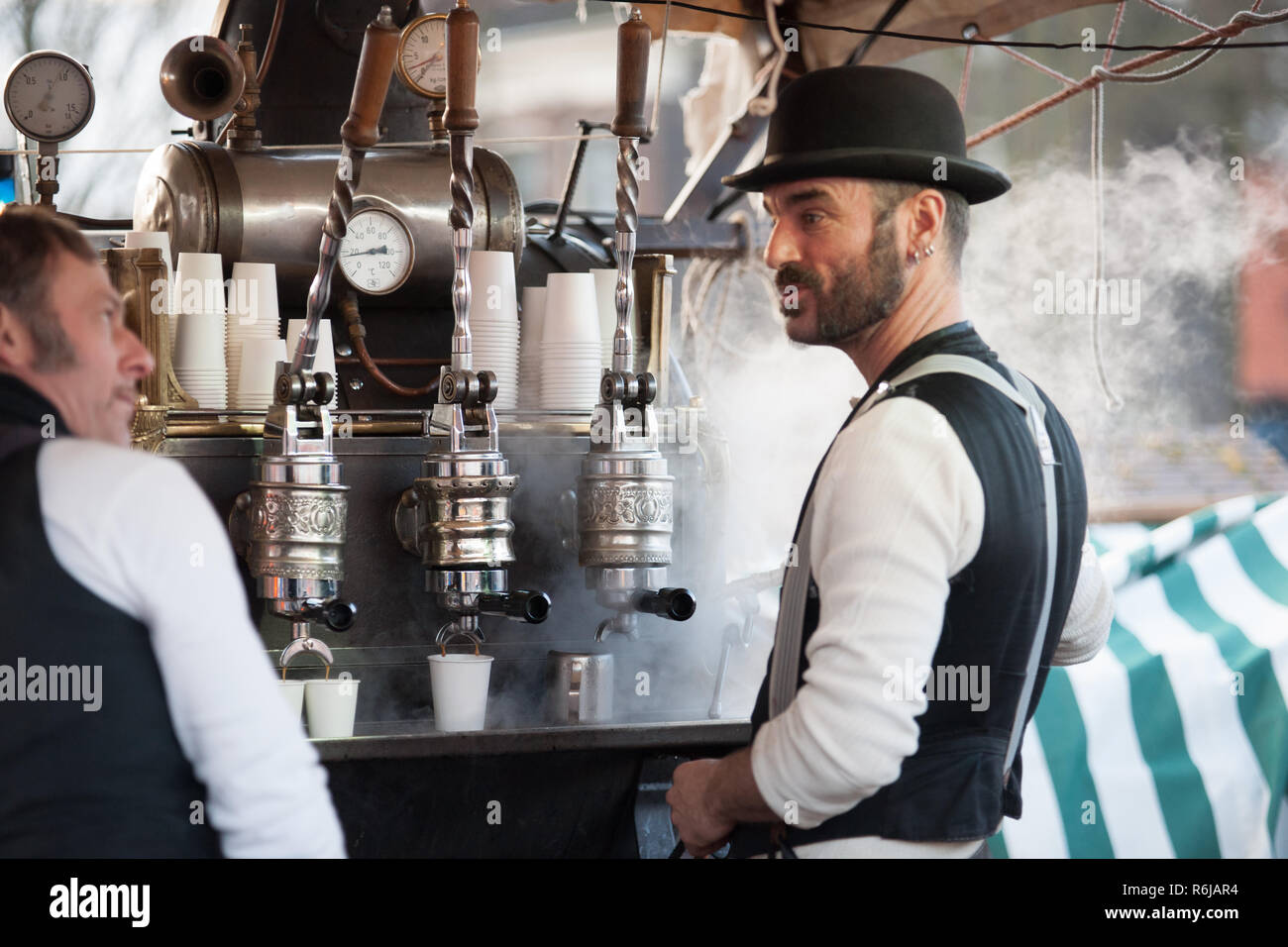 Vintage barista prepare coffee to customer in old style machine with ...