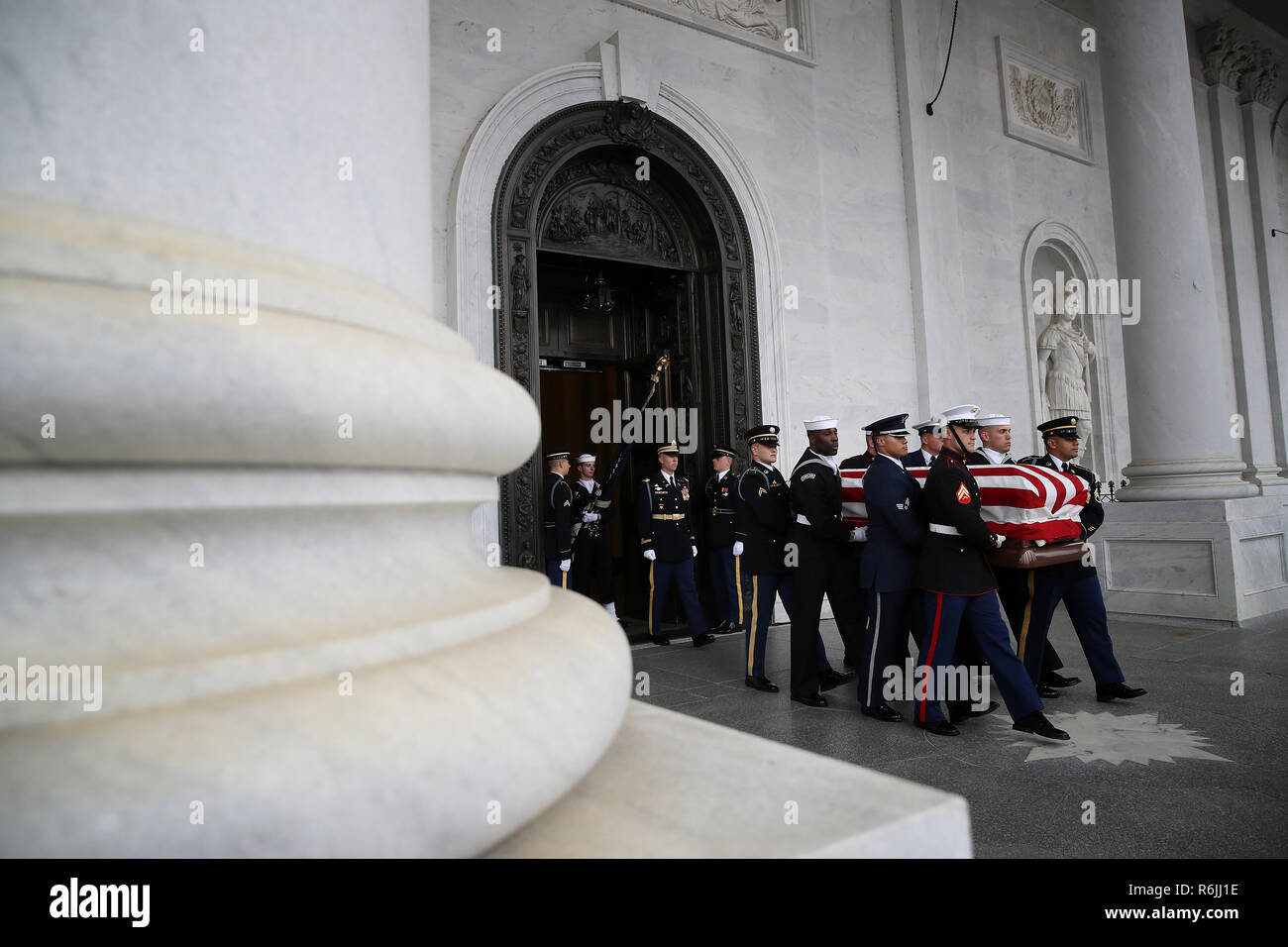 The flag-draped casket of former President George H. W. Bush is carried ...