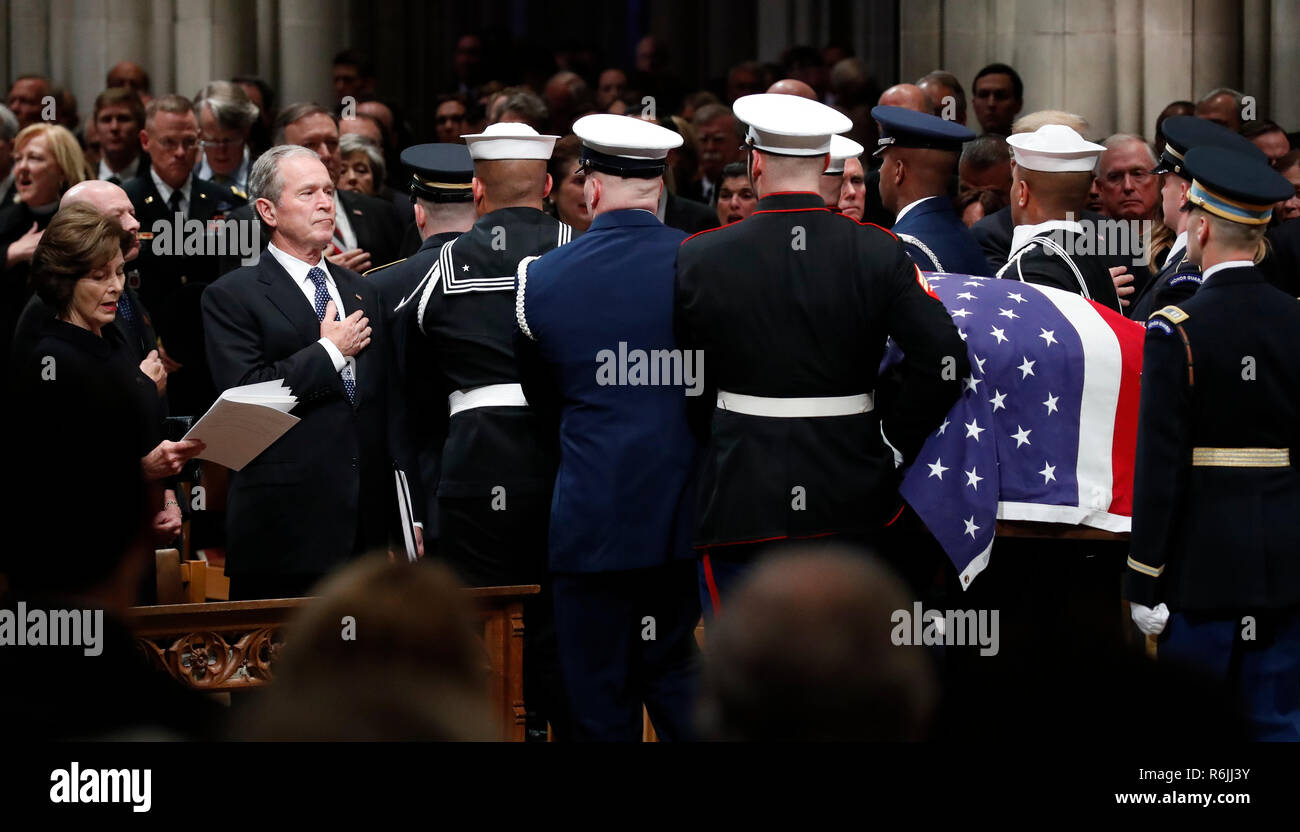 Former President George W. Bush places his hand over his heart as the ...