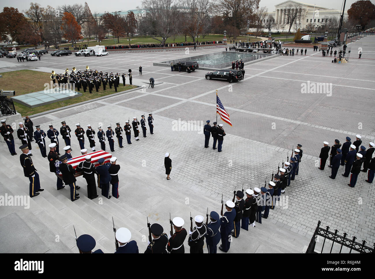 A U.S. military honor guard team carries the flag draped casket of ...