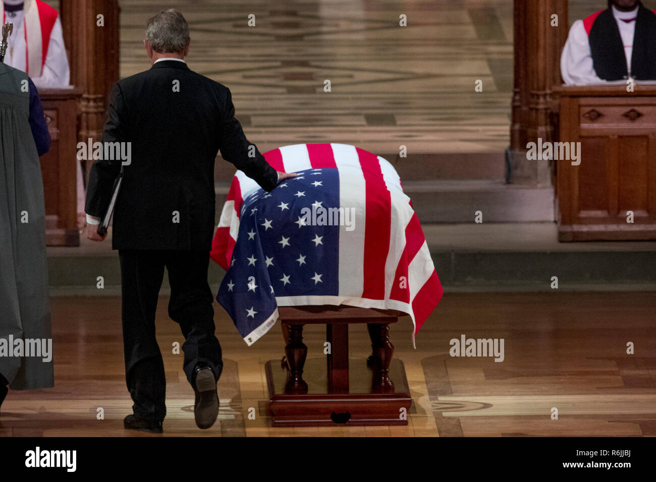 Former President George Bush touches the flag-draped casket of his ...