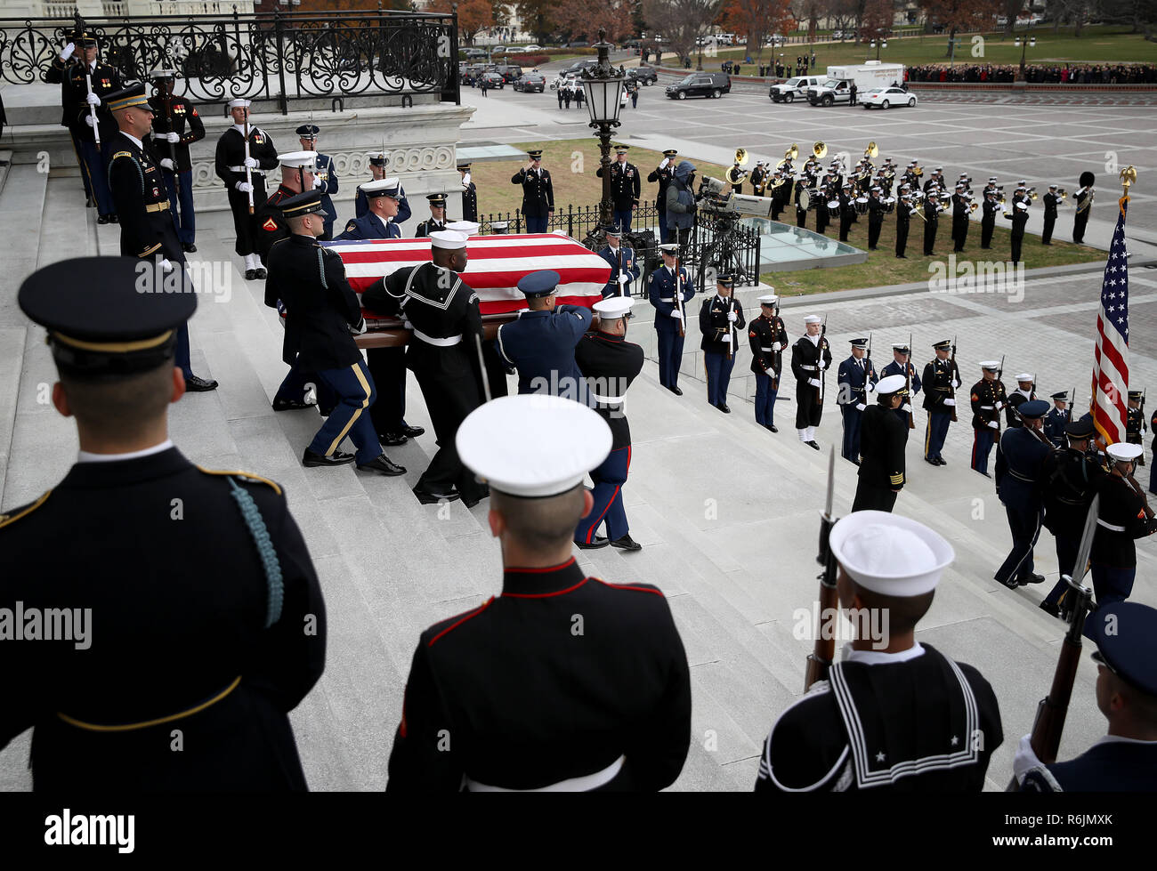 A U.S. military honor guard team carries the flag draped casket of ...