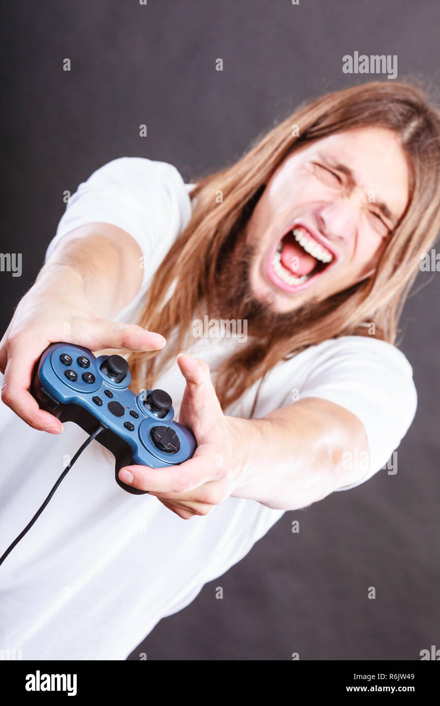 Addiction. Stressed depressed young man playing gaming on pad. Angry ...