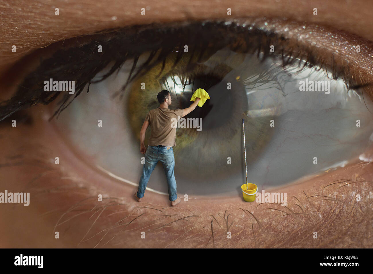 Male worker cleaning the surface of the pupil of the eye with a rag ...