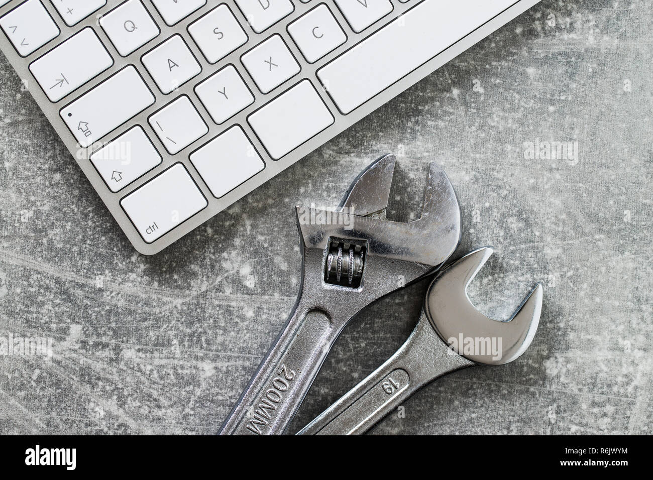 Wrench and computer keyboard. Metallic spanner Stock Photo - Alamy