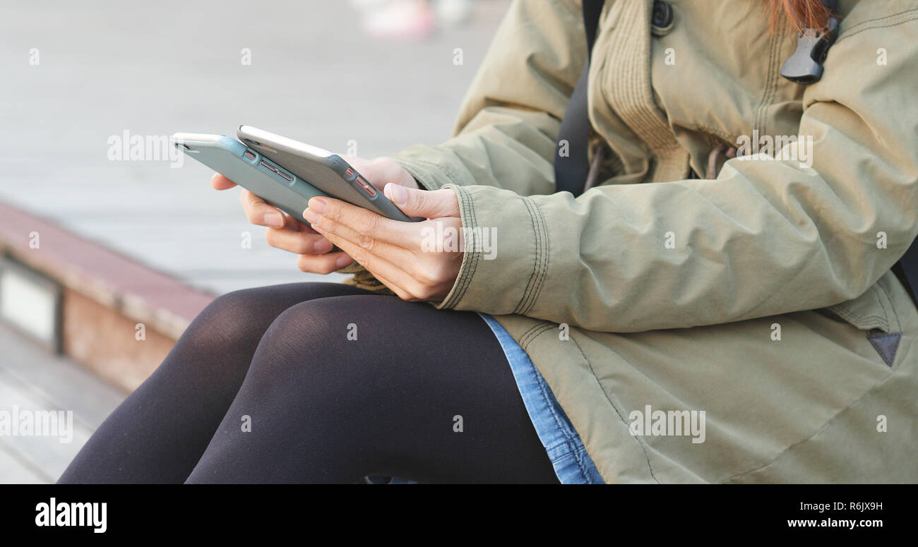 Busy woman keep using two cellphone Stock Photo - Alamy