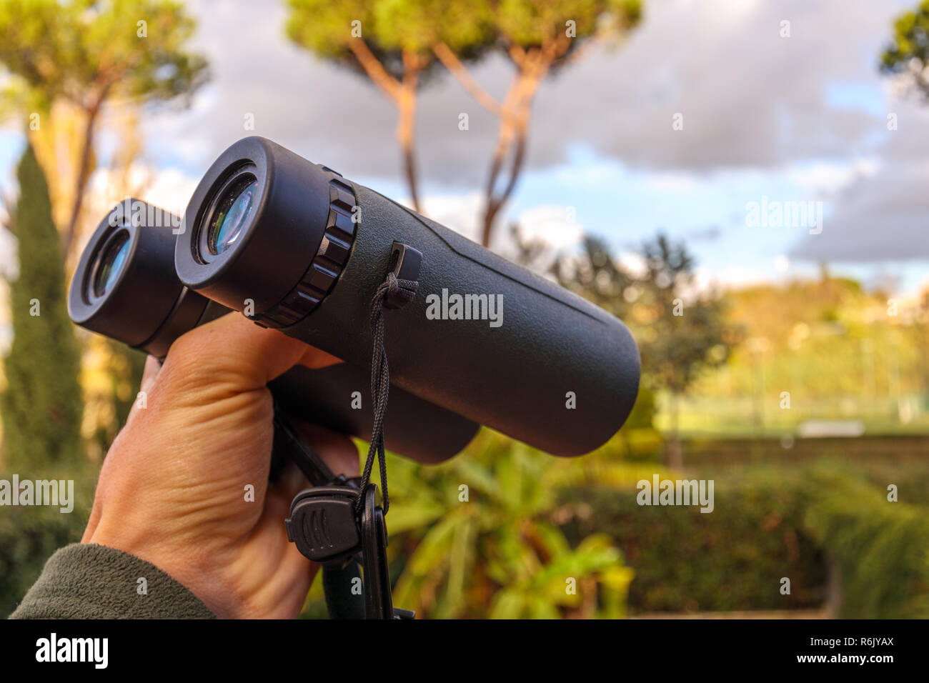 Green Binoculars in Hand with Landscape Stock Photo - Alamy