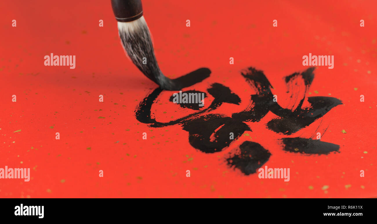 Writing chinese calligraphy with word meaning luck Stock Photo - Alamy