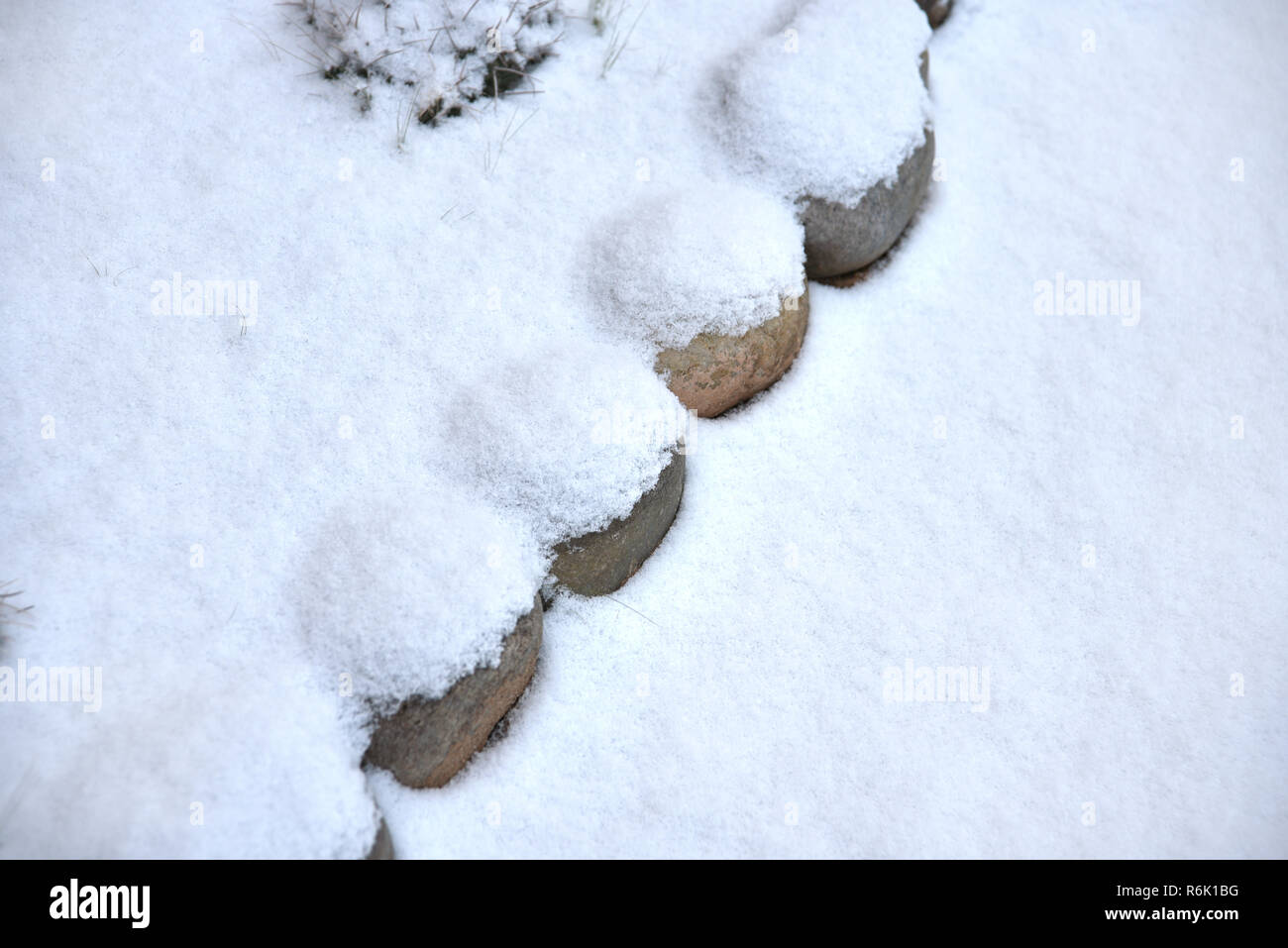 A light snowfall on round river rocks Stock Photo - Alamy