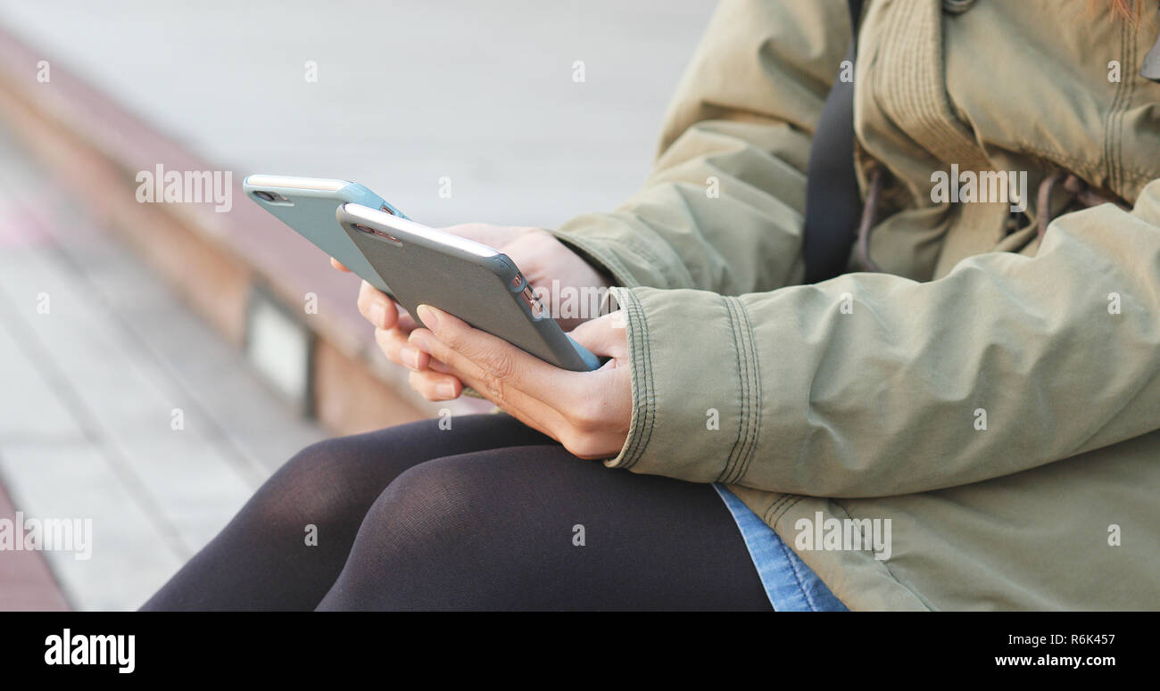 Busy woman keep using two cellphone Stock Photo - Alamy