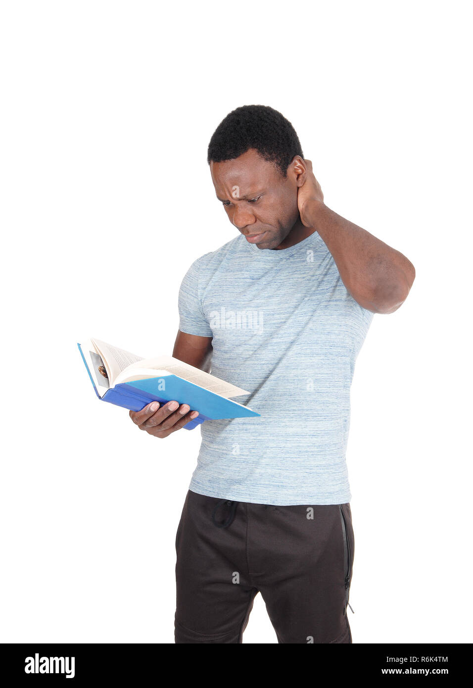 Puzzled African man looking at his book Stock Photo - Alamy